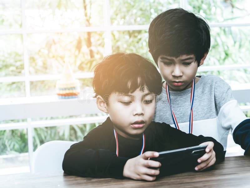 Two Little Boys Playing Online Game on Mobile Phone Stock Photo - Image ...