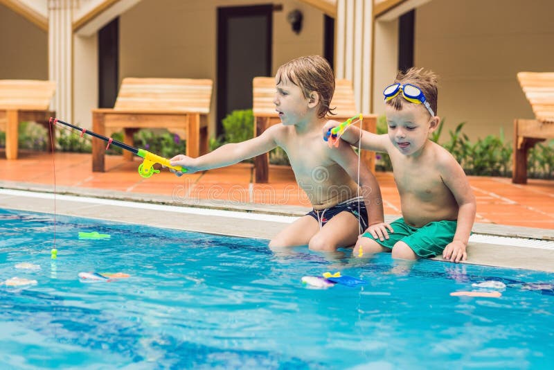 Two Little Cute Boy is Catching a Toy Fish in the Pool Stock Image ...