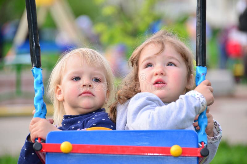 Two Little Girl on Swing Ride Stock Image - Image of freedom, garden ...