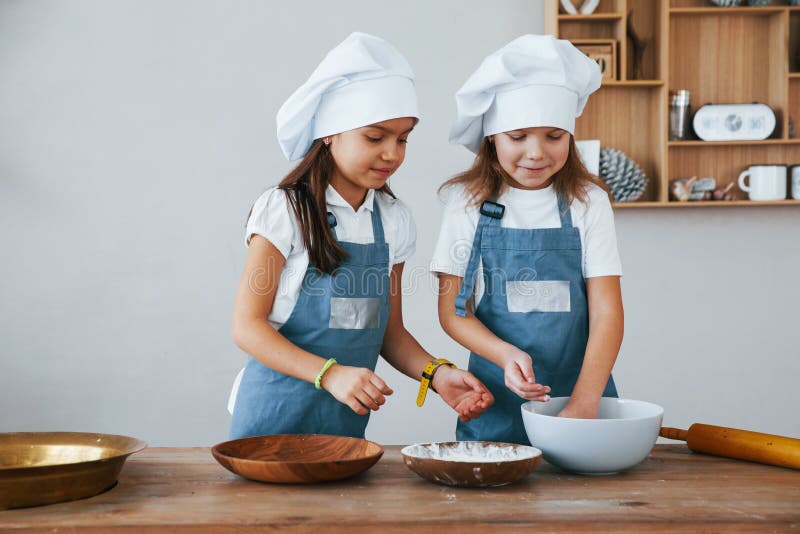 Two Little Girls in Blue Chef Uniform Working with Flour on the Kitchen ...