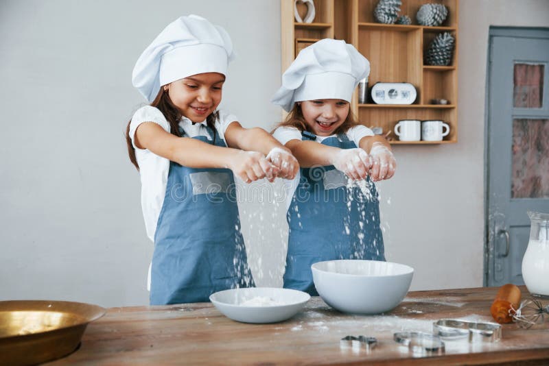 Two Little Girls in Blue Chef Uniform Working with Flour on the Kitchen ...