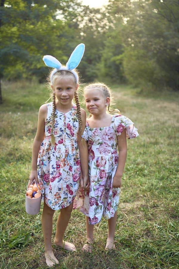 Two Little Girls Hug and Play Bunnies on Easter Egg Hunt Stock Photo ...