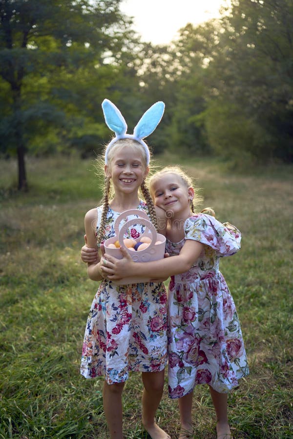 Two Little Girls Hug and Play Bunnies on Easter Egg Hunt Stock Photo ...