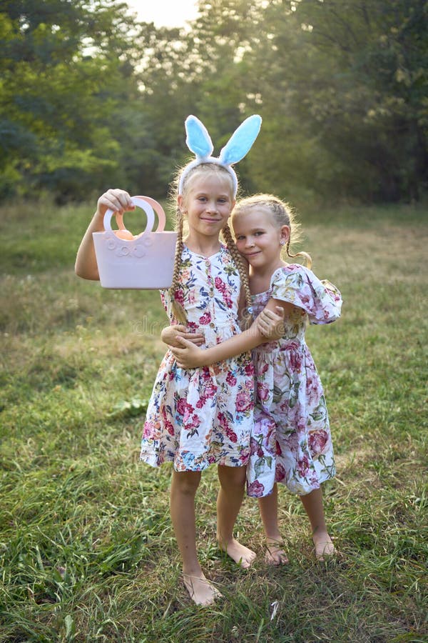 Two Little Girls Hug and Play Bunnies on Easter Egg Hunt Stock Image ...
