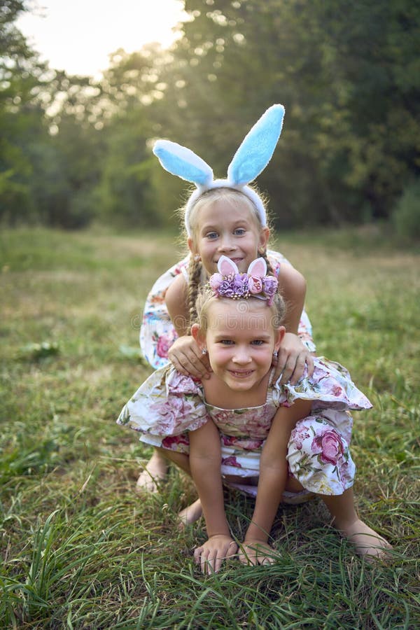 Two Little Girls Hug and Play Bunnies on Easter Egg Hunt Stock Image ...