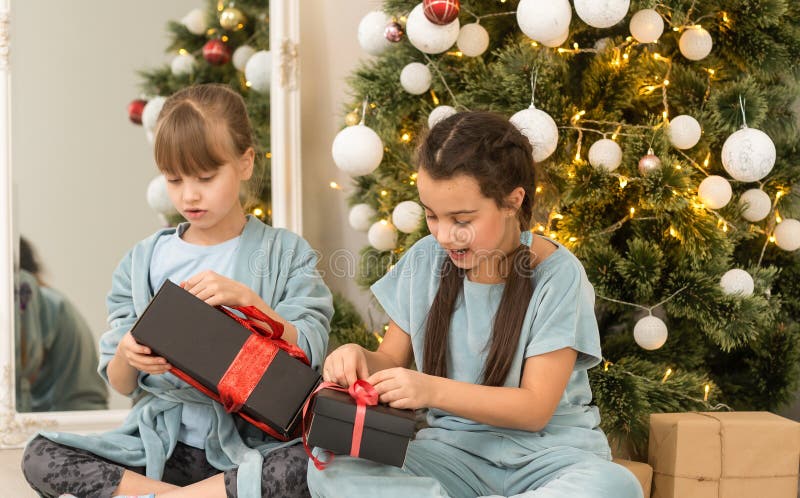 Two Little Girls Open Christmas Present Under the Christmas Tree Stock ...