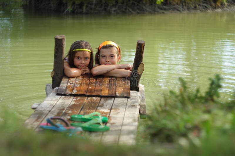 Two Little Girls Playing in the Farm Lake Stock Image - Image of ...