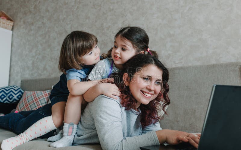 Two Little Girls Sit on Their Mother S Back while Working on the ...