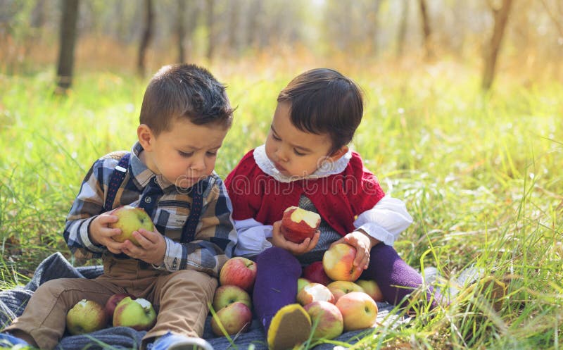 Two Little Kids Eating Apples in the Park in Autumn Stock Image - Image ...
