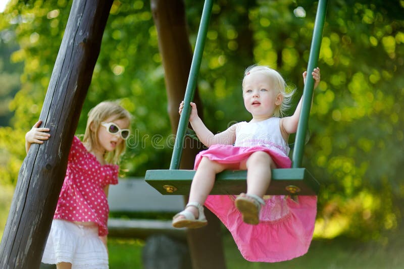 Two Little Sisters Having Fun on a Swing Stock Image - Image of little ...