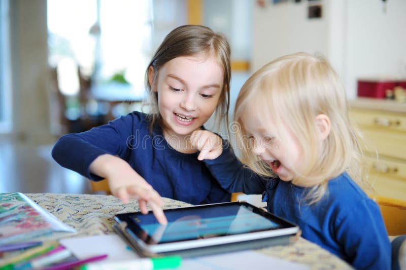 Two Little Sisters Playing with a Digital Tablet Stock Image - Image of ...