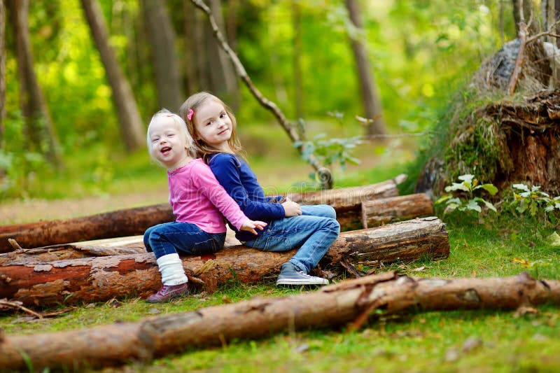 Two Little Sisters Sitting on a Log in a Forest Stock Image - Image of ...