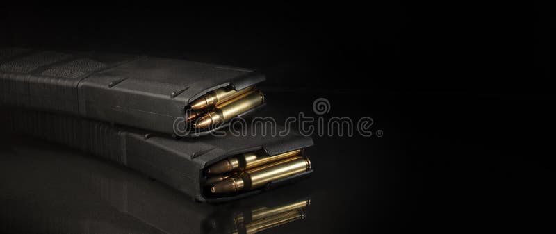 Two Loaded AR-15 Magazines on a Black Background with a Reflection and ...