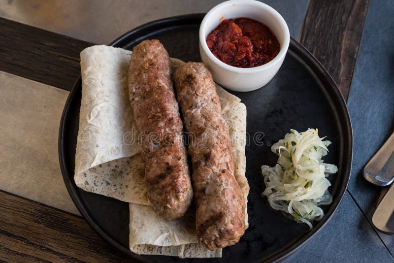 Two Lula Kebabs on Pita Bread with Onions and Red Tomato Sauce Stock ...