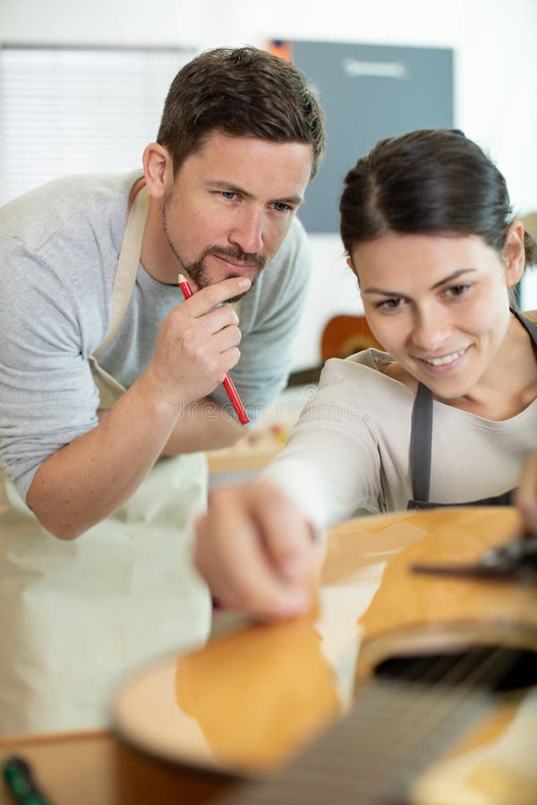 Two Luthiers Work on New Guitar with Precision and Care Stock Photo ...