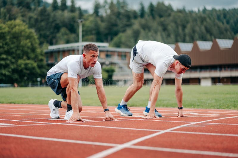 Two Male Athletes Posed To Run on a Track in the Sunshine Stock Image ...