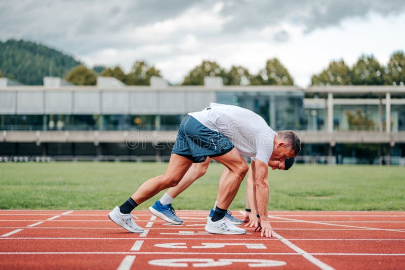 Two Male Athletes Posed To Run on a Track in the Sunshine Stock Image ...