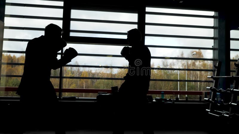 Two Male Boxers Training in the Dark Gym Near the Window with Daylight ... Two Male Boxers Training in the Dark Gym Near the Window with Daylight ...