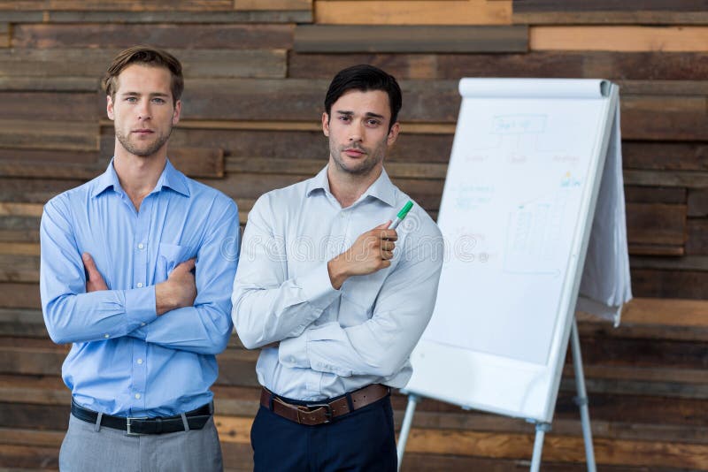 Two Male Business Executives in a Meeting Standing in Front of a Flip ...