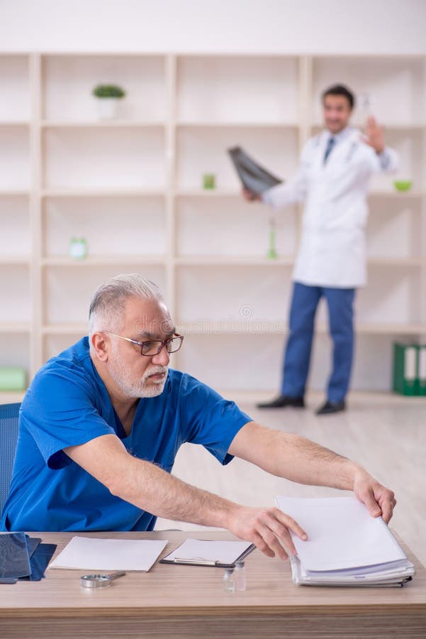Two Male Doctors Working in the Clinic Stock Photo - Image of medicine ...