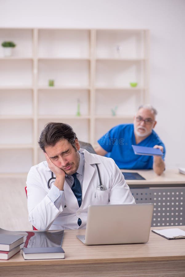 Two Male Doctors Working in the Clinic Stock Image - Image of suffering ...