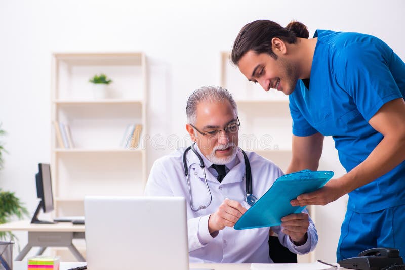 Two Male Doctors Working in the Clinic Stock Photo - Image of notes ...