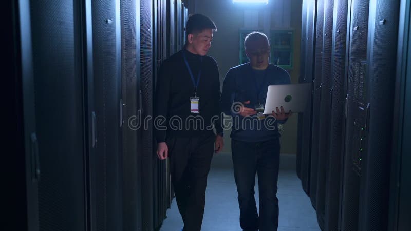 Two Male Engineers Talking and Using Laptop while Walking in Data ...