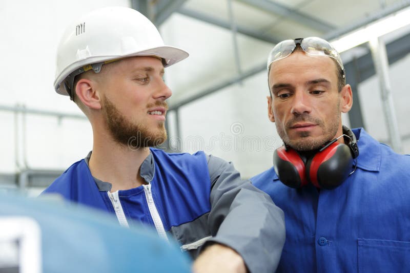 Two Male Mechanics Wear Work Clothes in Large Garage for Safety ...