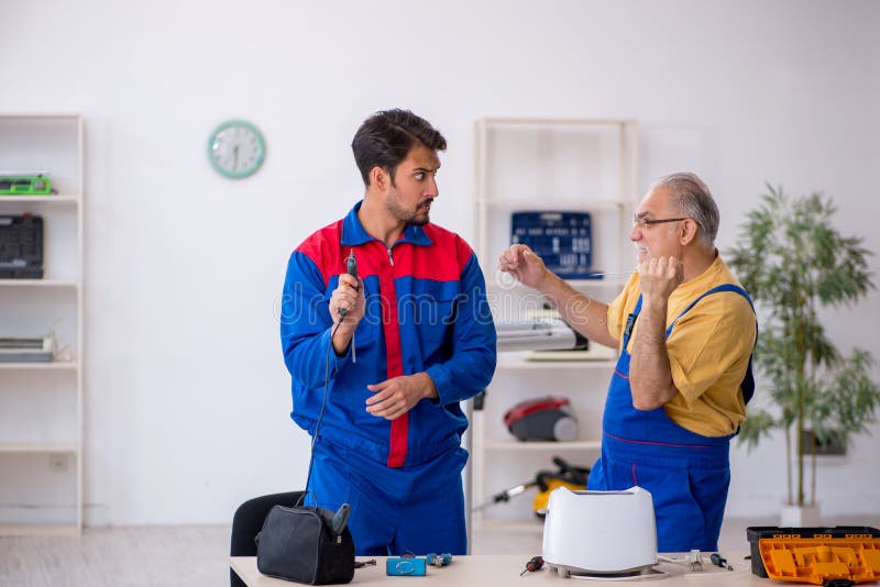 Two Male Repairmen Working at Workshop Stock Photo - Image of disorder ...