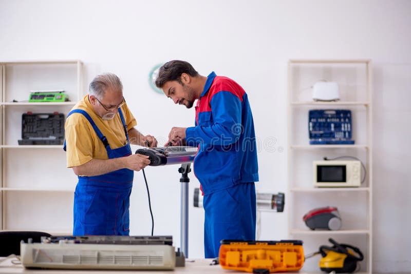 Two Male Repairmen Working at Workshop Stock Photo - Image of disorder ...