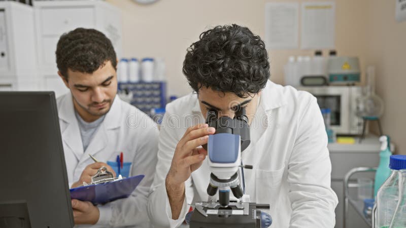 Scientists Working Laboratory Using Microscope Taking Notes Stock ...