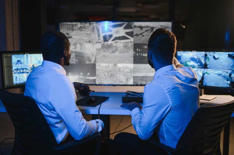 Two Male Security Guards Looking at Computer Screen while One of Them ...