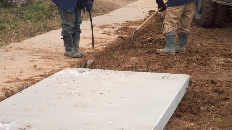 Two Man Construction Workers Dig the Ground To Lay Cement Concrete ...