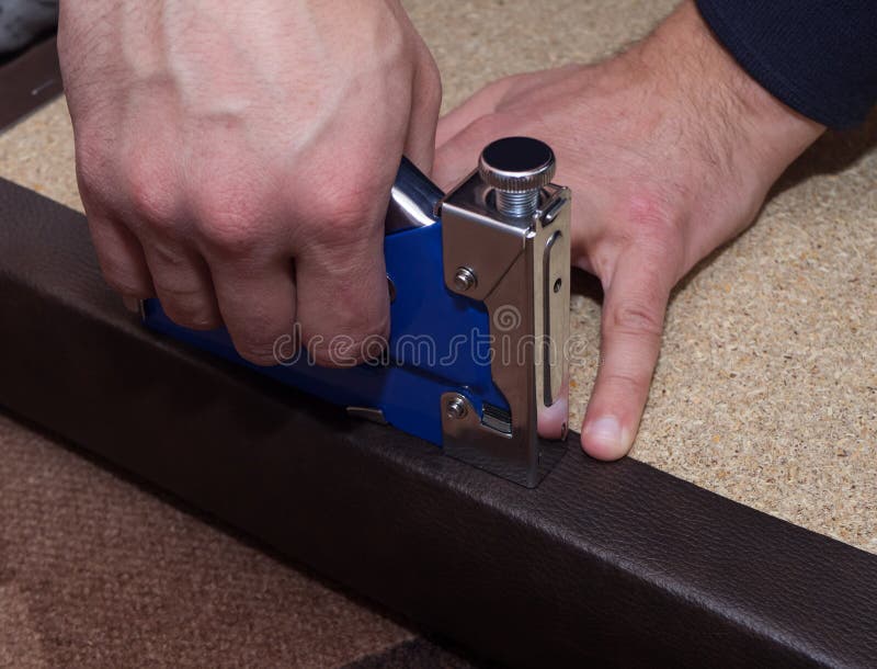 Two Man Hands Using Stapler and Staples Upholstering Paricle Board with ...