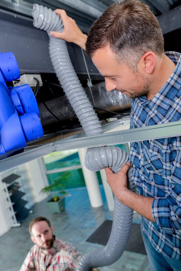 Two man installing tubes stock image. Image of help - 123021357