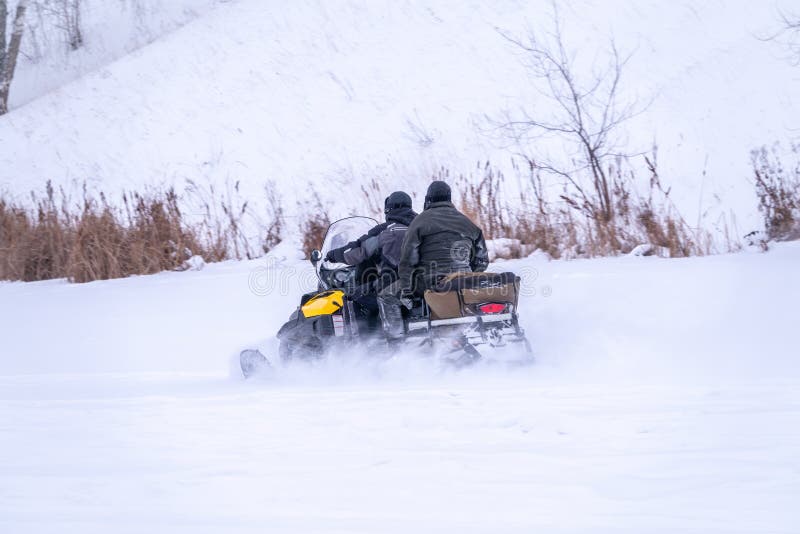 Two Man on a Snowmobile Riding on the Snow Surface in the Winter Forest ...