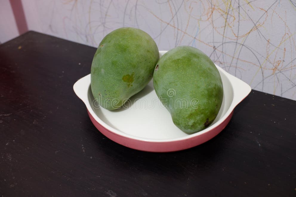 Two mangoes on the plate stock photo. Image of green - 306751298