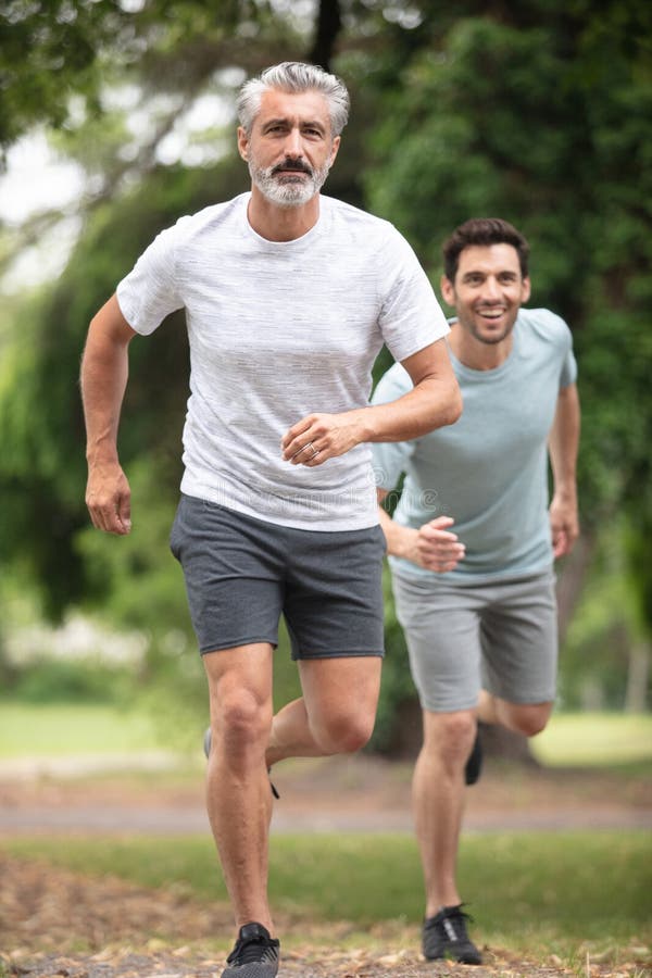 Two Mature Men Jogging in Park Stock Image - Image of athletic ...
