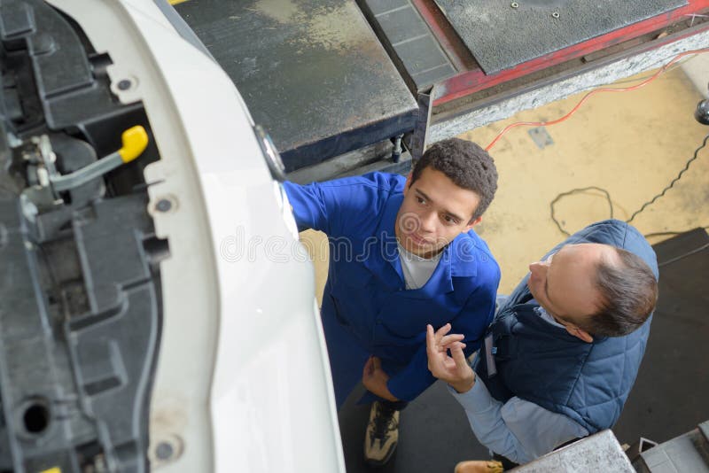 Two mechanic repairing car stock image. Image of suspension - 229443545
