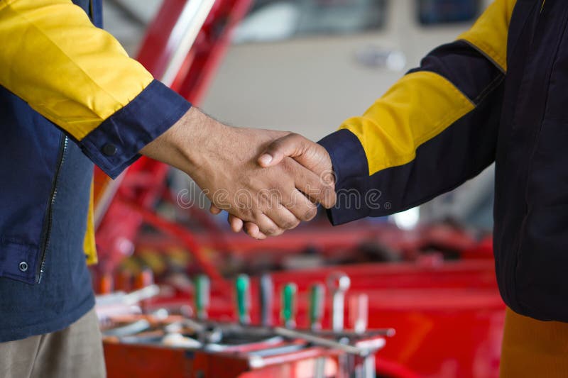 Two Mechanic in Work Uniform Engaged in a Handshake. Atmosphere in ...