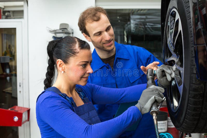 Car Mechanics Changing Wheel Working on Hydraulic Lift Stock Photo ...