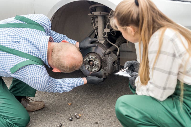 Two Mechanics Examining Brake Disk in Car Stock Image - Image of male ...