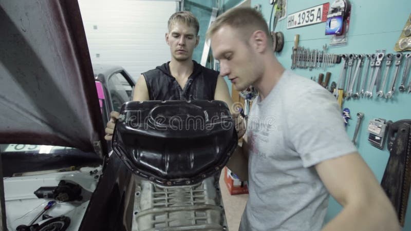 Profile of Two Mechanics Works with Car at Garage. Portraits of ...