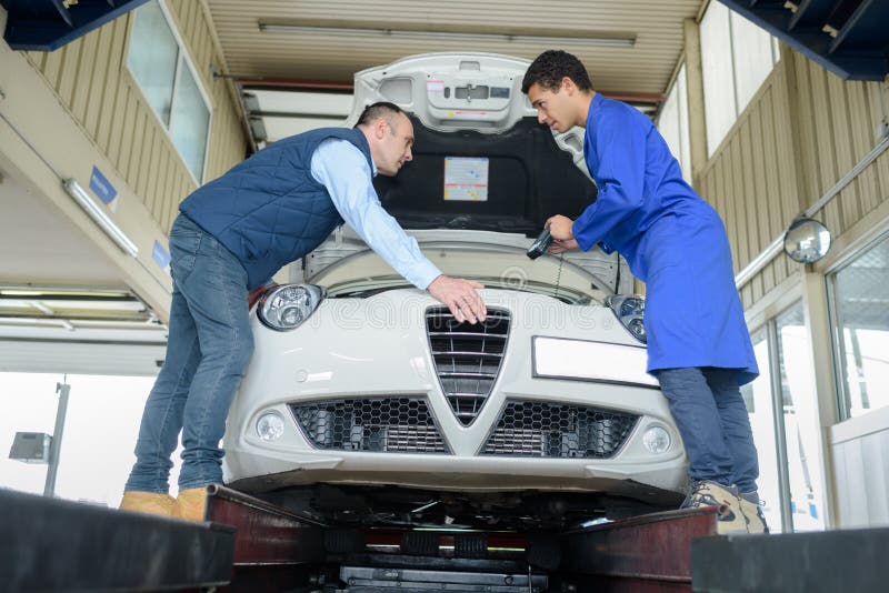 Two Mechanics Working on Car Engine at Garage Stock Image - Image of ...