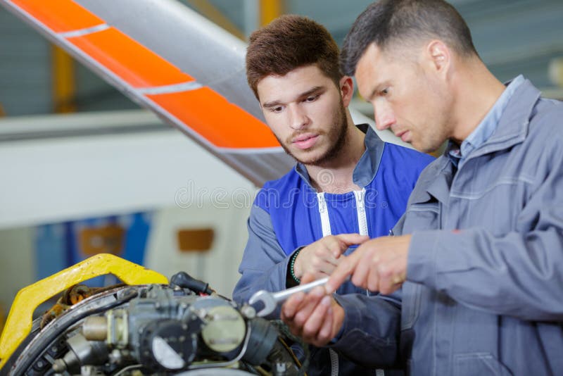 Two Mechanics Working on Aircraft in Hangar Stock Image - Image of ...
