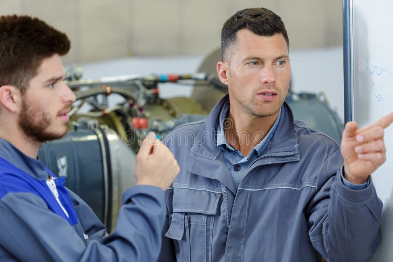 Two Mechanics Working on Aircraft in Hangar Stock Photo - Image of ...