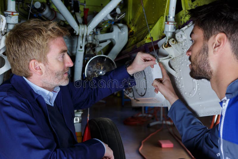 Two Mechanics Working on Aircraft Stock Photo - Image of open ...