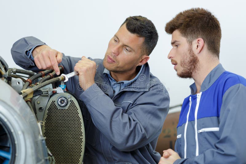 Two Mechanics Working Together Stock Image - Image of uniform, tool ...