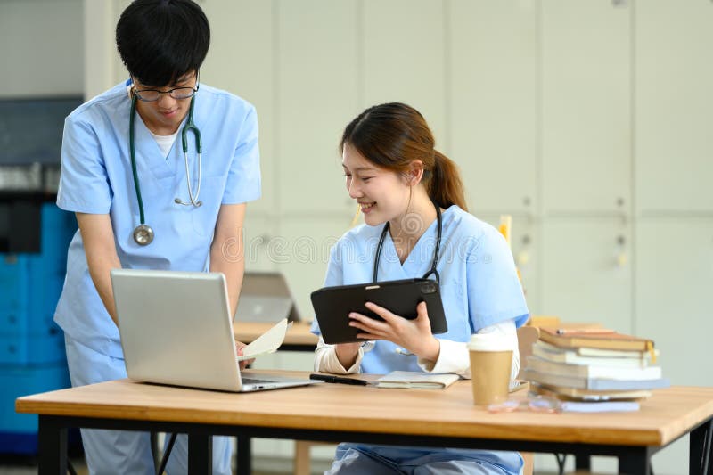 Two Medical Students Discussing and Analyzing Information on a Laptop ...