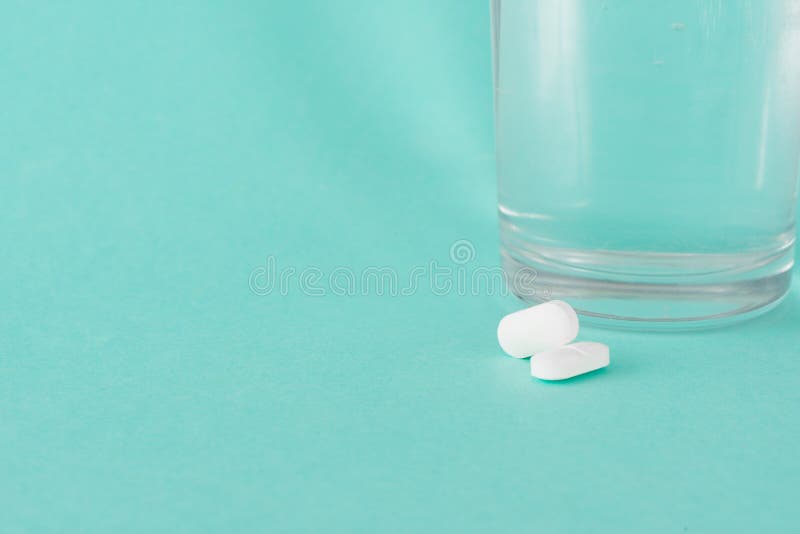 Two Medicinal Tablets and a Glass of Water Copy Space Stock Photo ...
